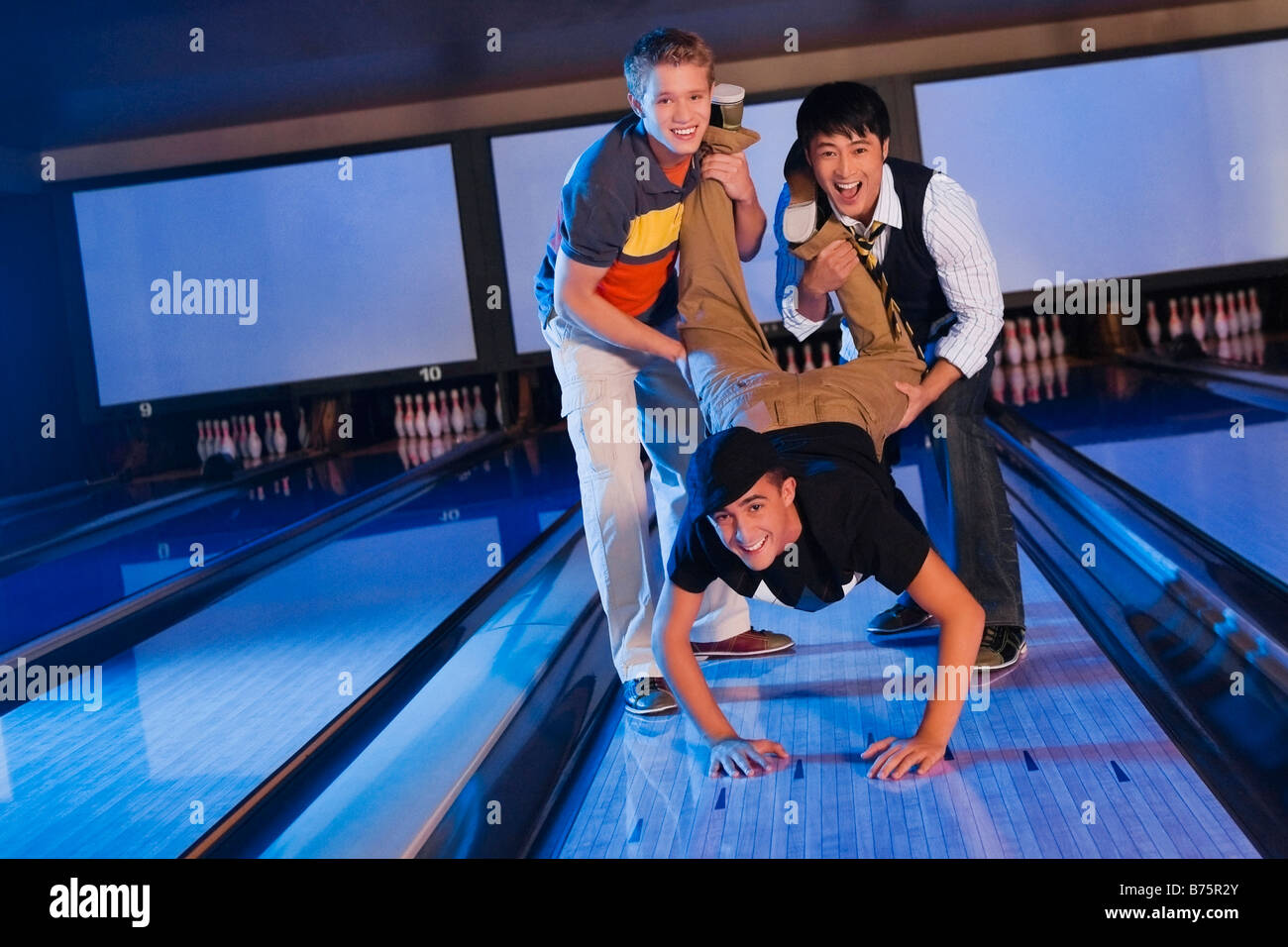 Portrait of three friends having fun in a bowling alley Stock Photo - Alamy