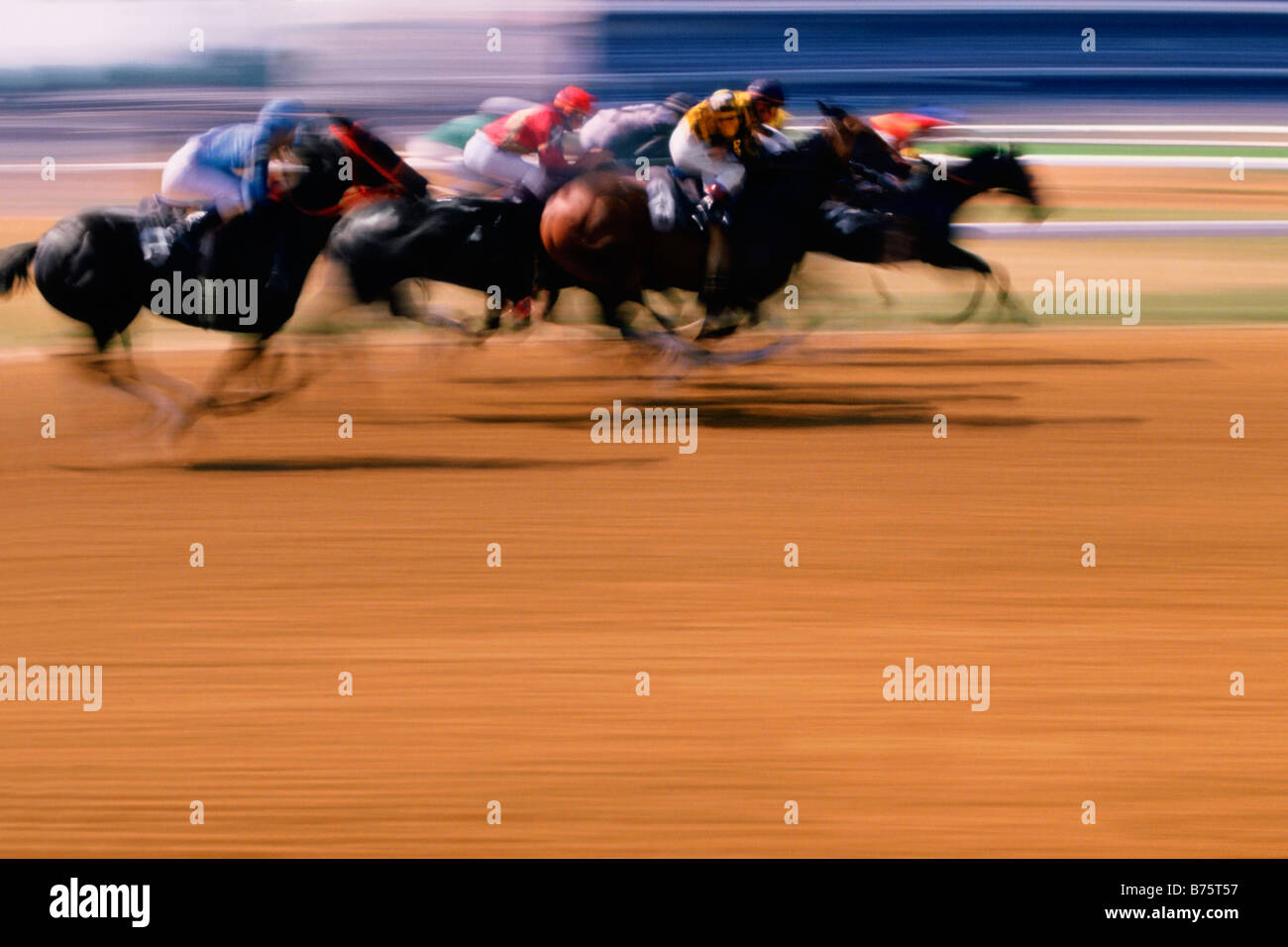 Jockeys riding their horses on a running track Stock Photo - Alamy
