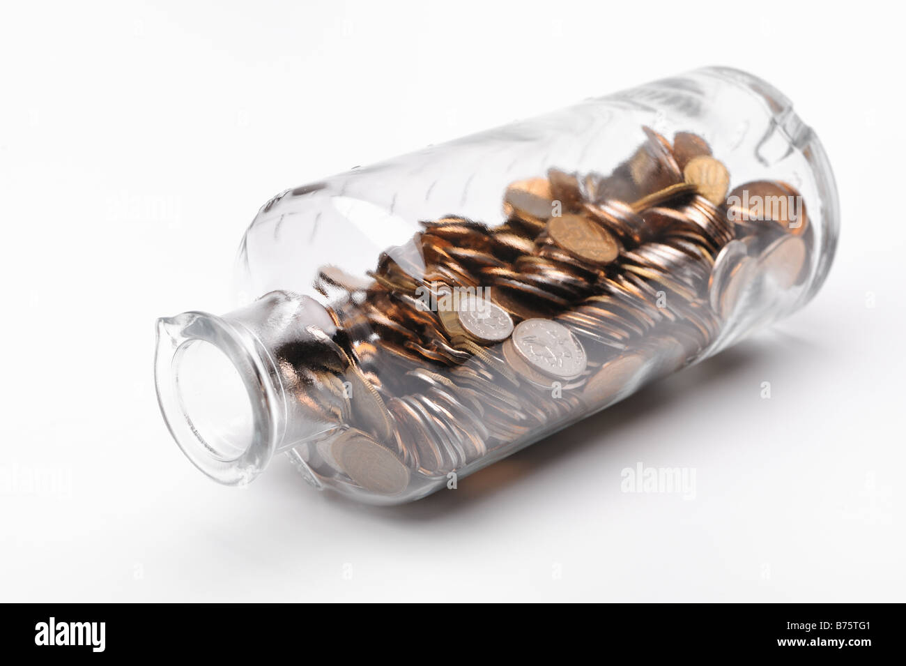 Glass bottle full of coins on a white background Stock Photo - Alamy