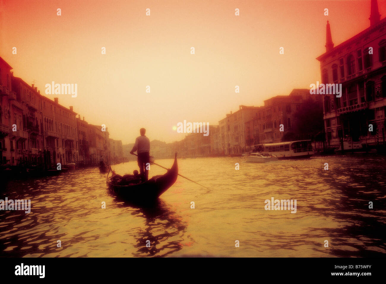 Gondolier rowing a gondola in a canal, Grand Canal, Venice, Veneto ...