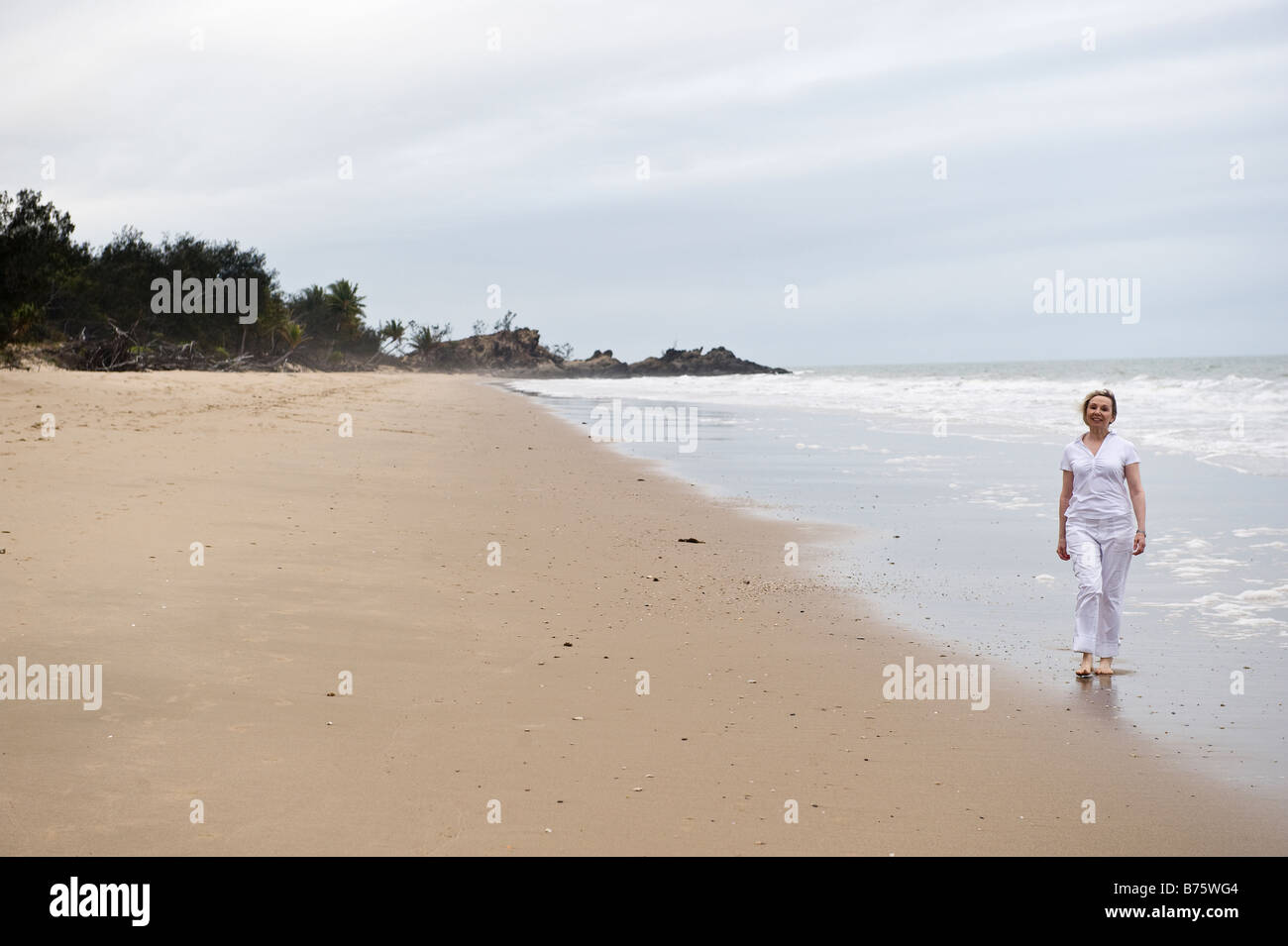 Lady strolling on the beach Stock Photo - Alamy