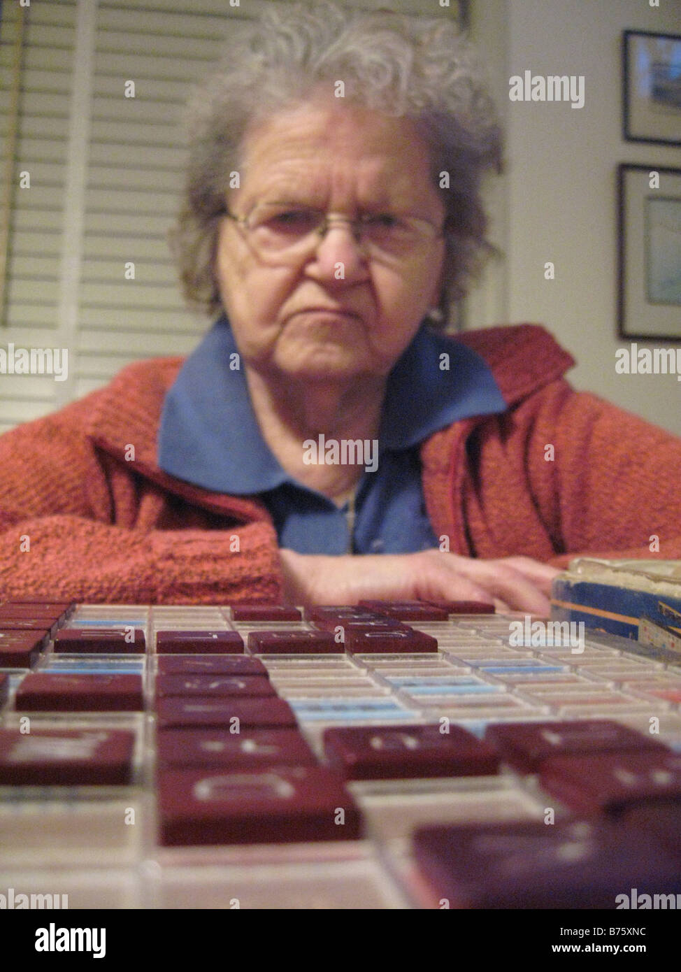 Table level view of old lady scowling at Scrabble board Stock Photo - Alamy