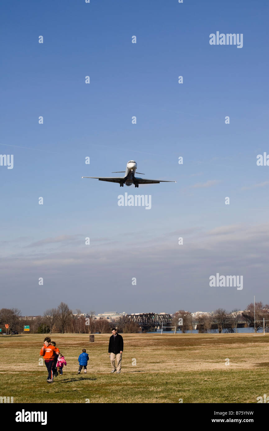 A commuter airplane flying over a city park Stock Photo - Alamy