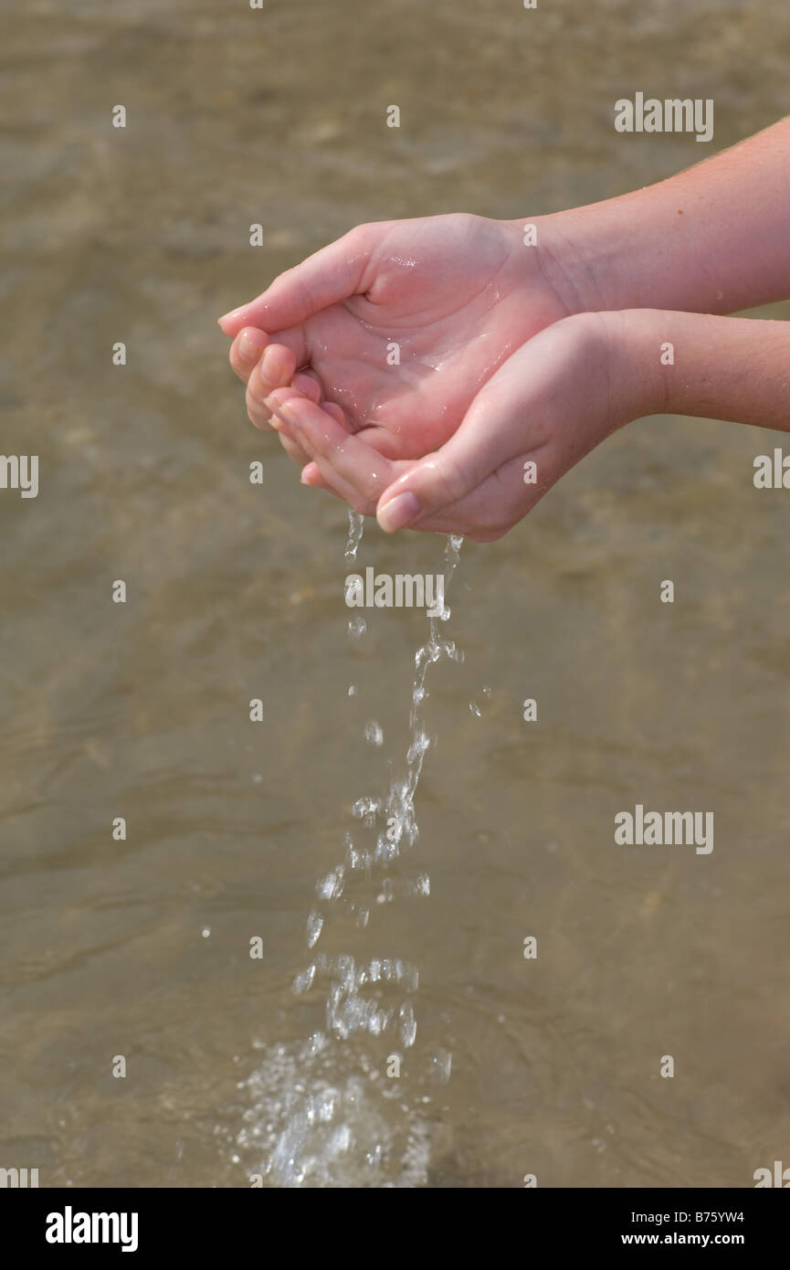 Water passing through a childs hands at beach Stock Photo - Alamy