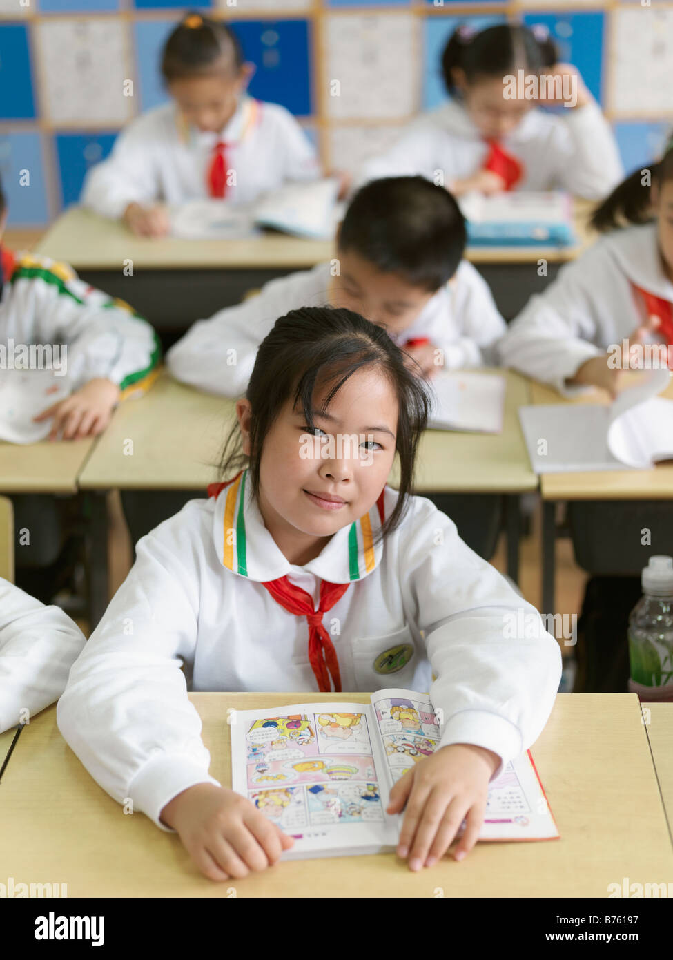 A classroom of young students reading a lesson from their textbook ...