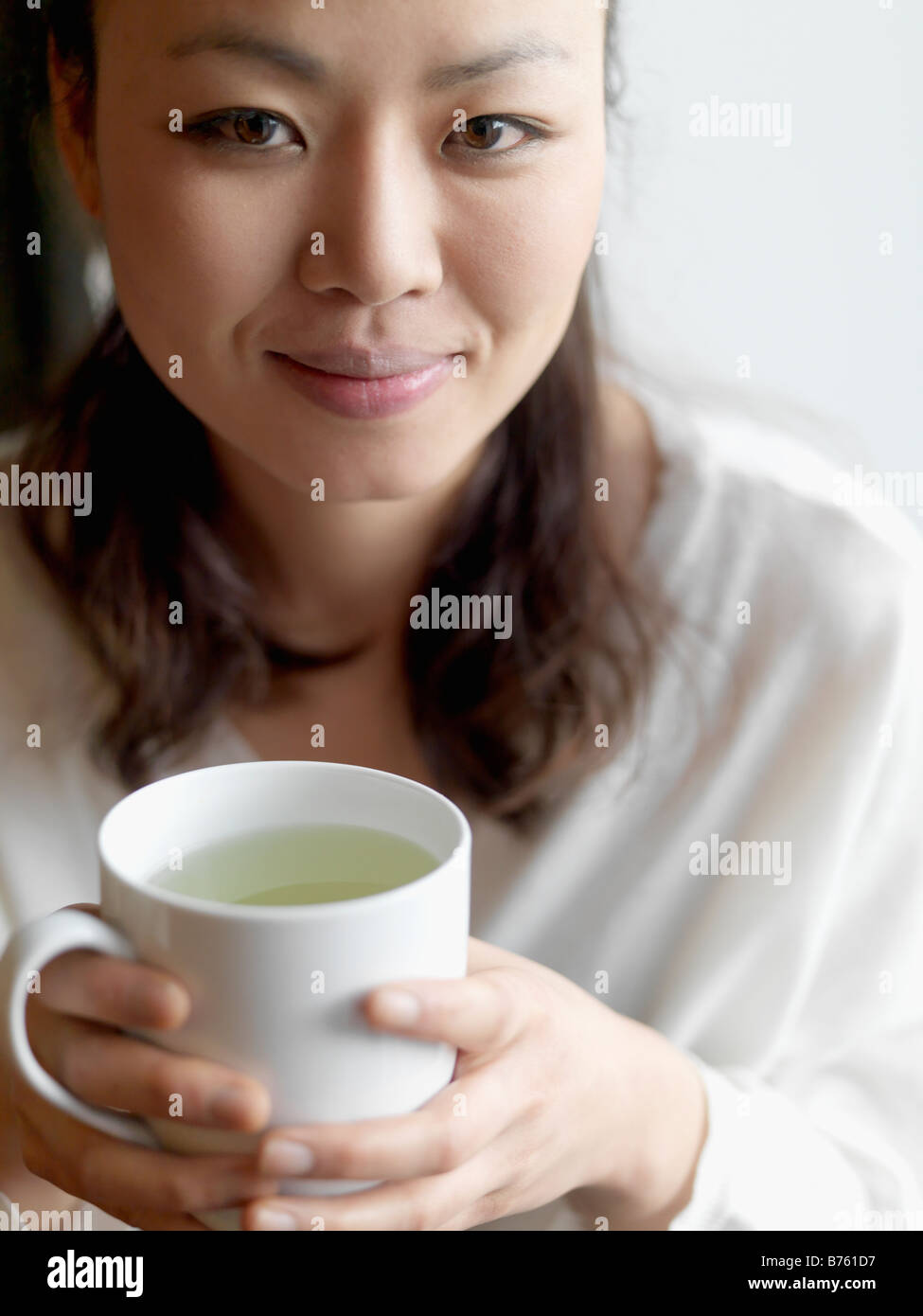 A young Asian woman enjoying a cup of green tea Stock Photo - Alamy