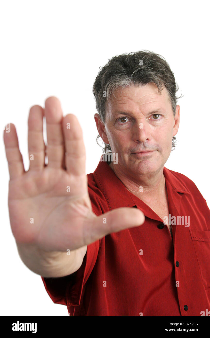 A handsome serious man holding his hand out in a stop gesture Focus on ...