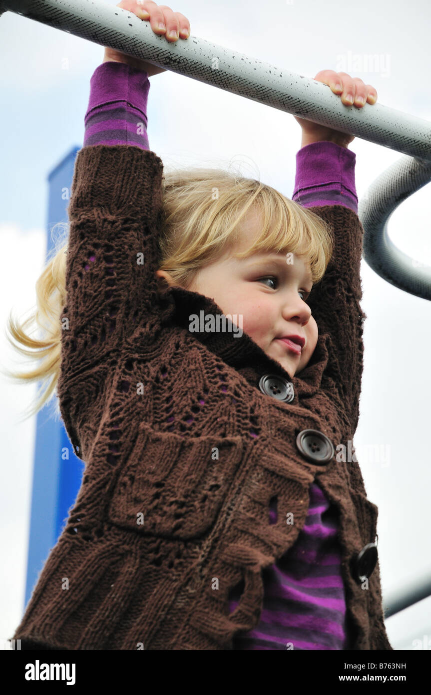 Girl hanging from monkey bars hi-res stock photography and images - Alamy