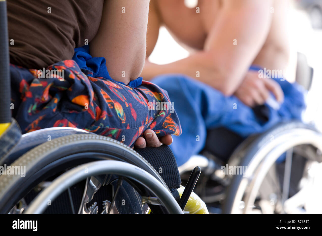 Two people on wheelchairs sitting face to face, mid section, close-up ...