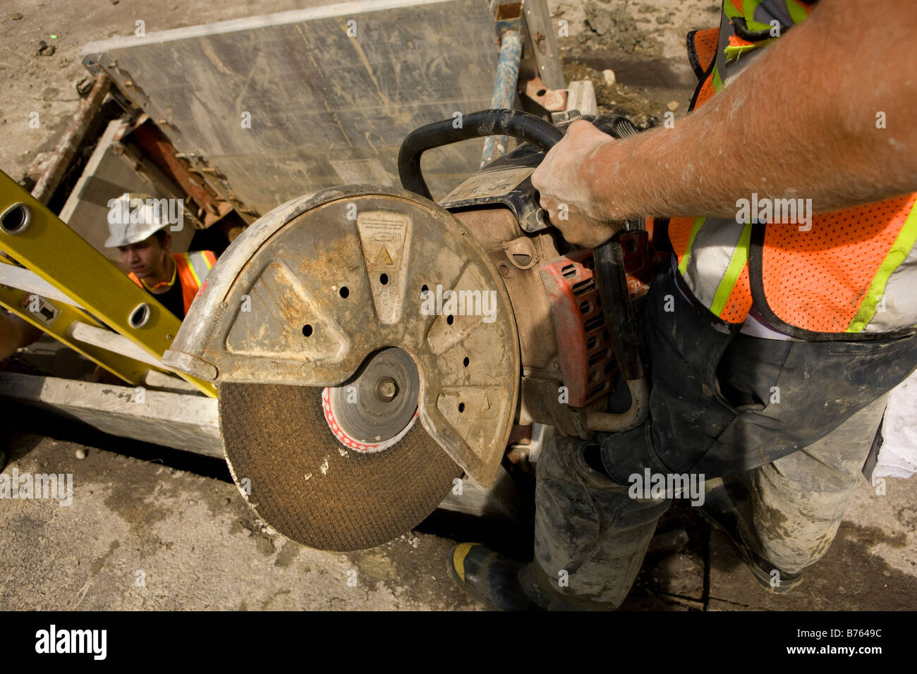 Worker with saw on construction site, mid section Stock Photo - Alamy