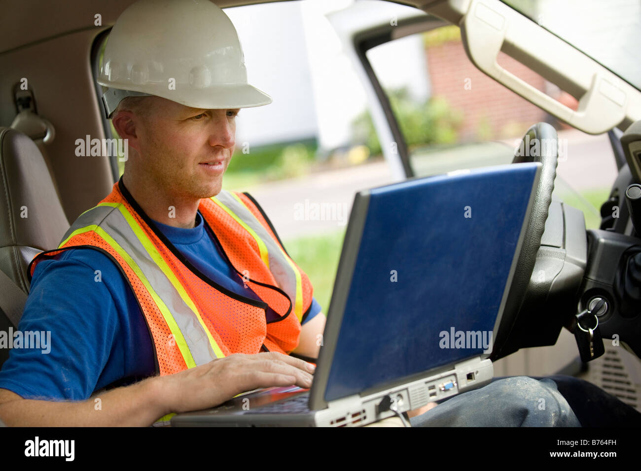 Construction worker using laptop in truck Stock Photo - Alamy