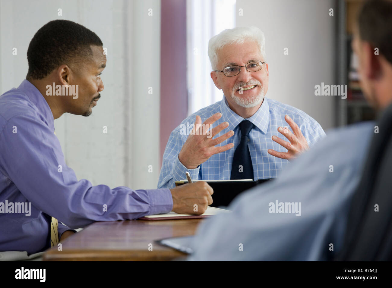 Three businessmen having meeting Stock Photo - Alamy
