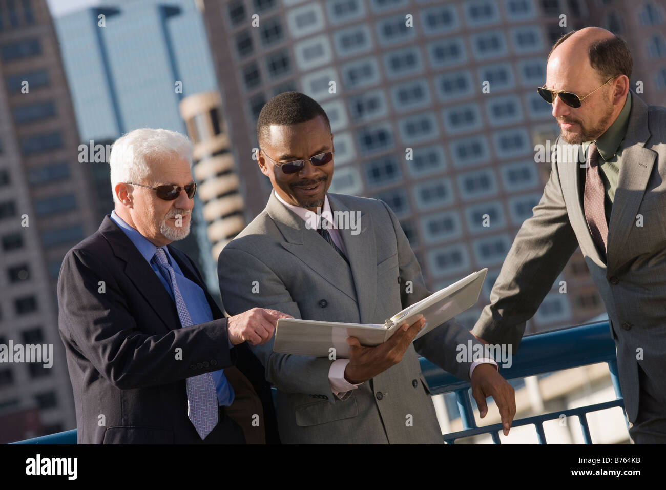 Three businessmen talking on bridge Stock Photo - Alamy