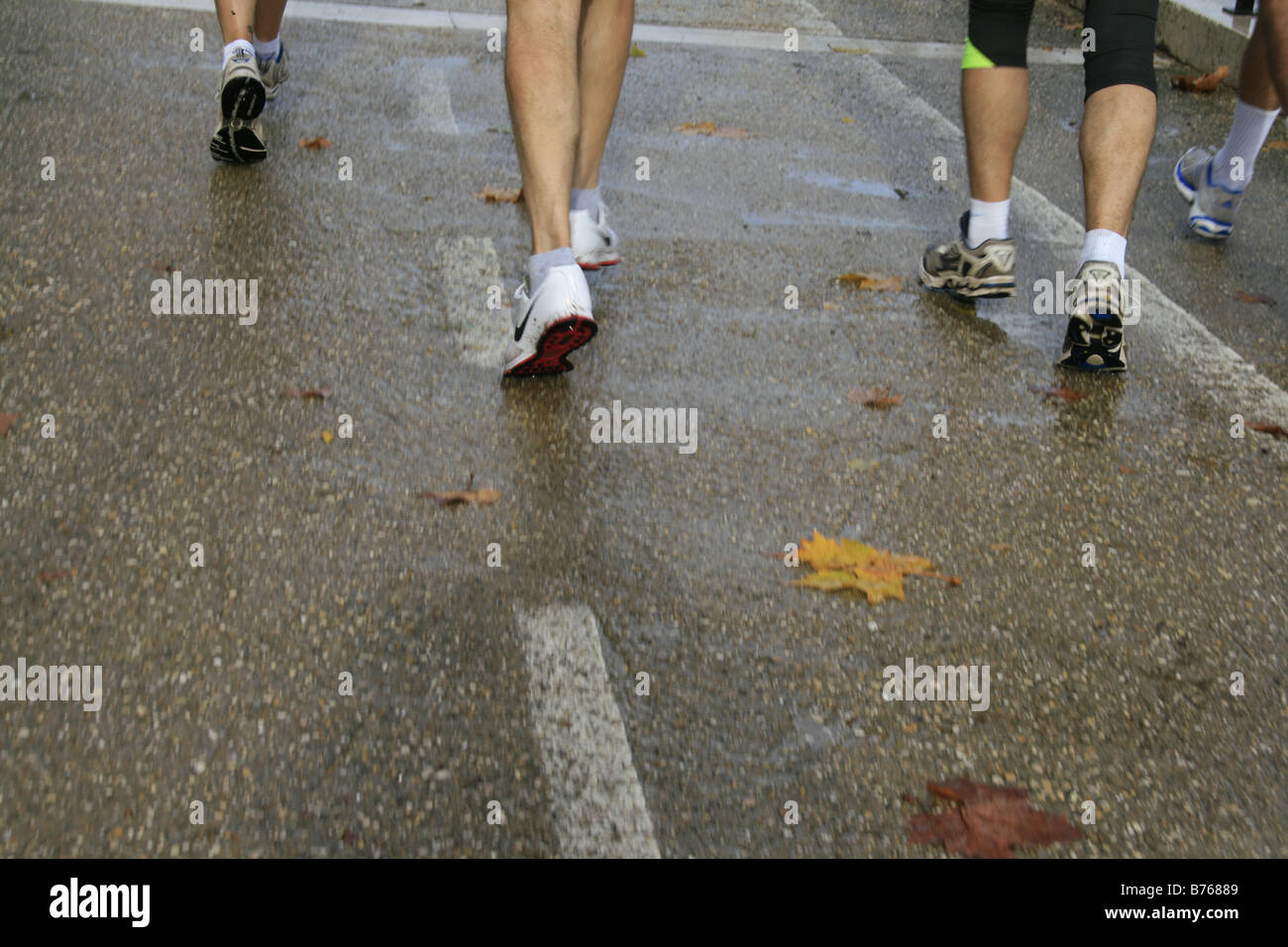 three runners in action on country lane in road race Stock Photo - Alamy