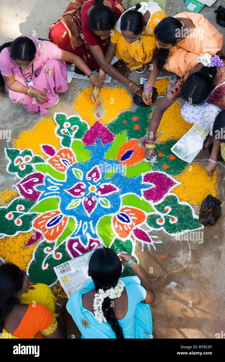 Indian teenage girls making rangoli festival designs in the street ...
