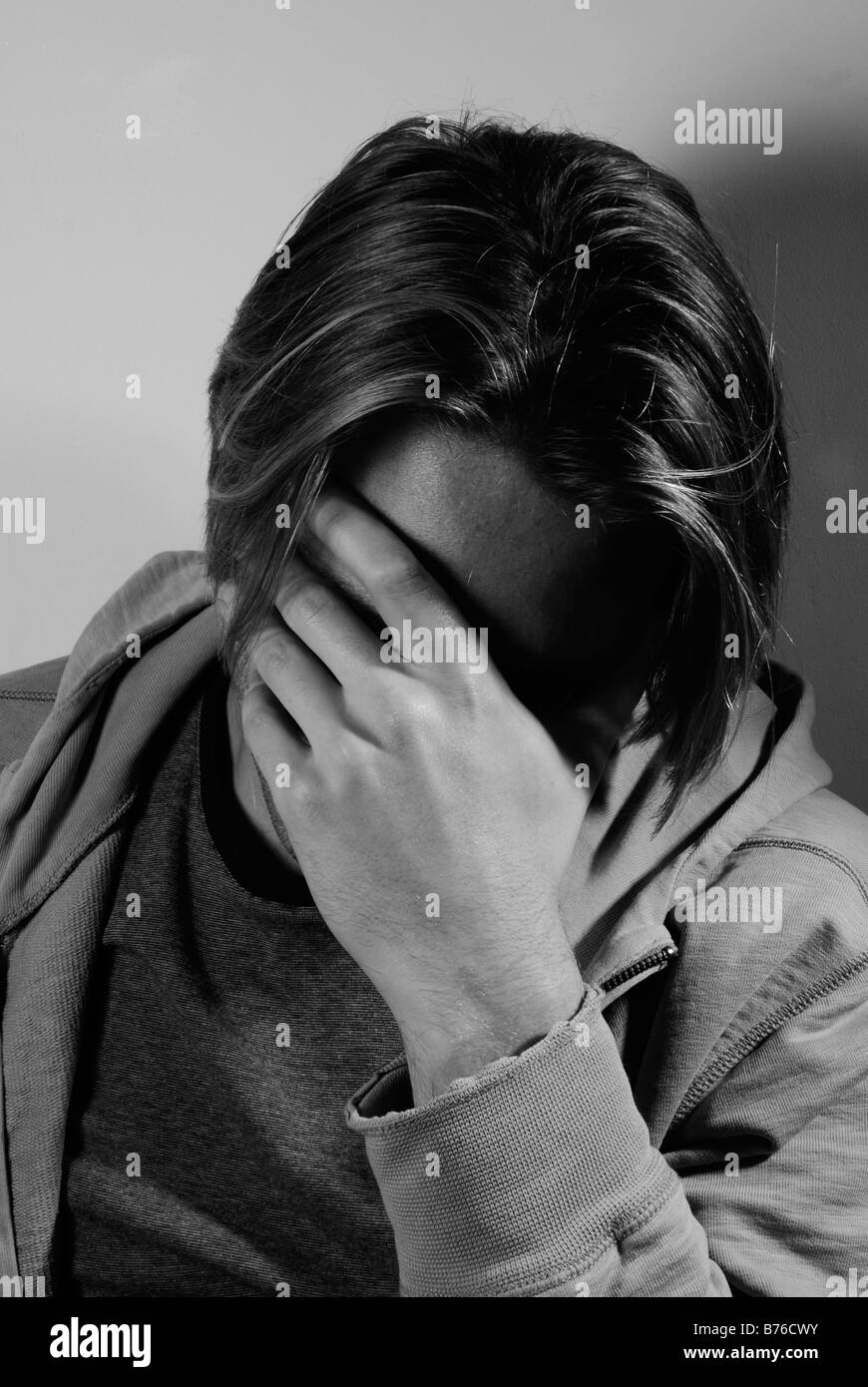 Man with head in hand Stock Photo - Alamy