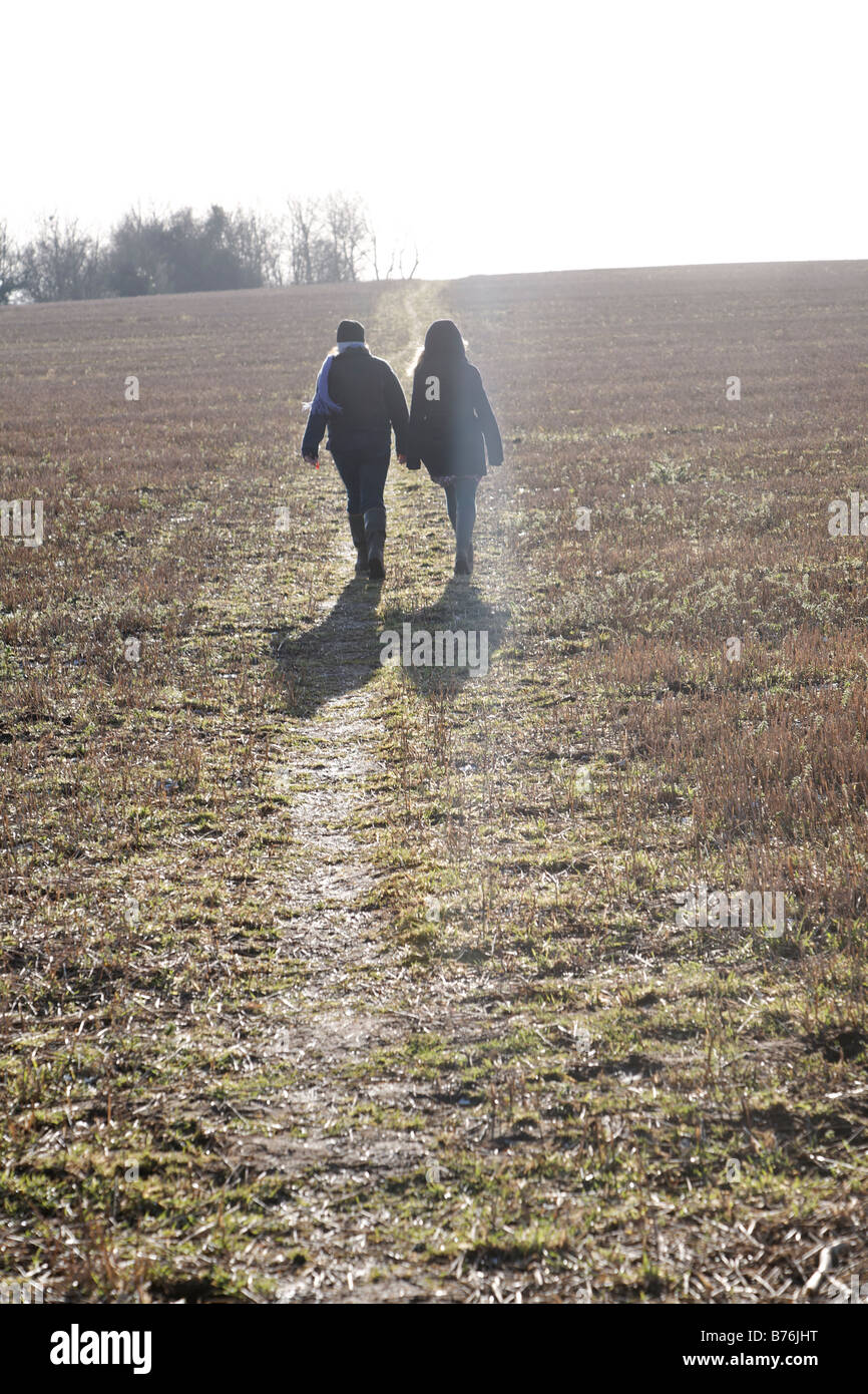 Lens flare view into sun with mother and daughter on winter walk on ...