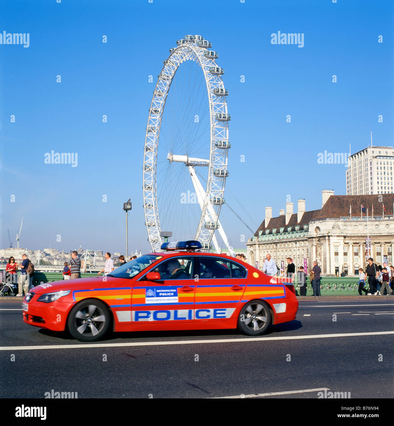 The London Eye and a red London Metropolitan police car crossing ...
