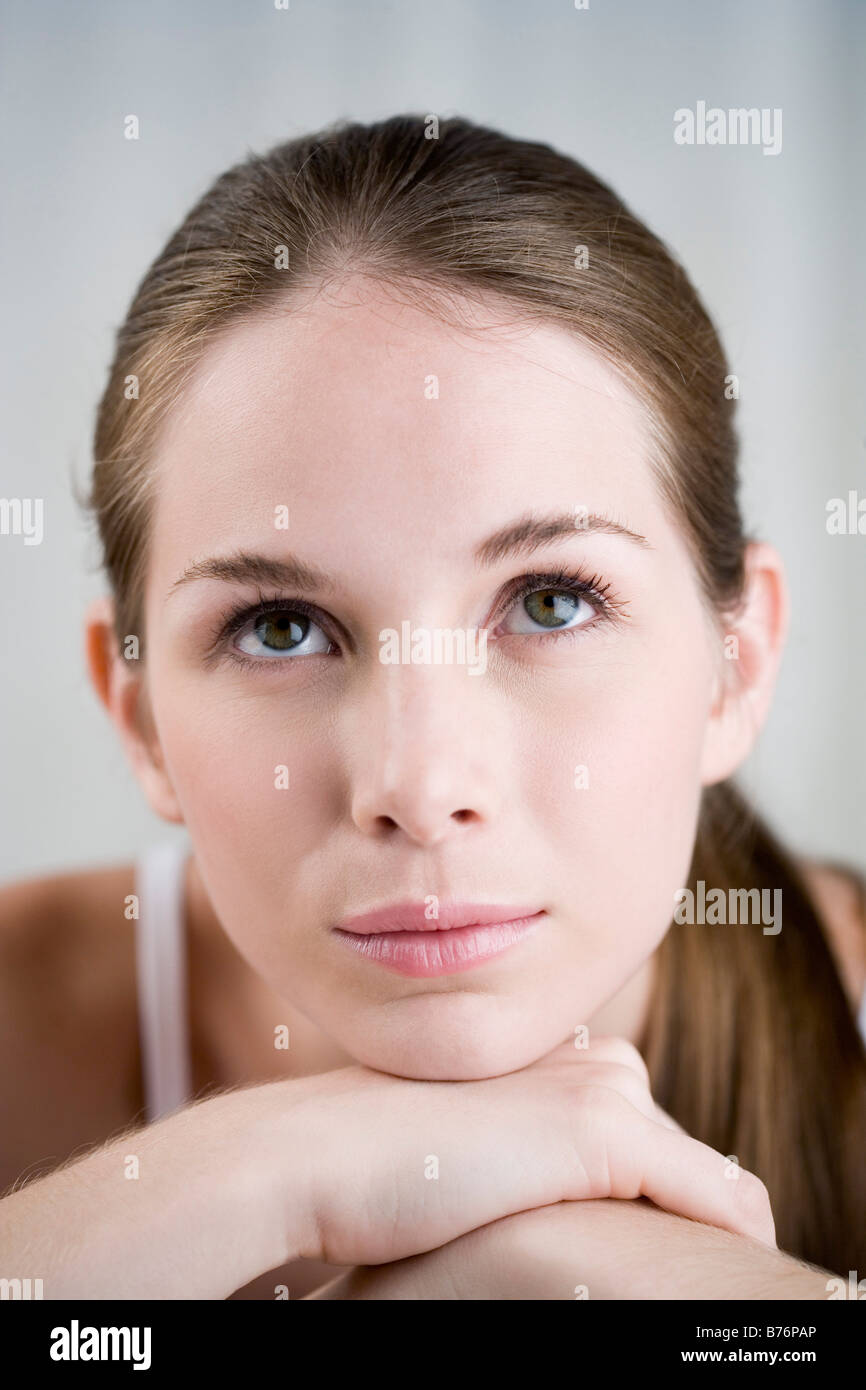 Young woman with hands on chin Stock Photo - Alamy