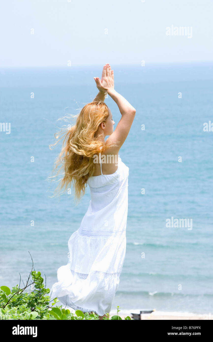 Young woman in prayer position on beach Stock Photo - Alamy