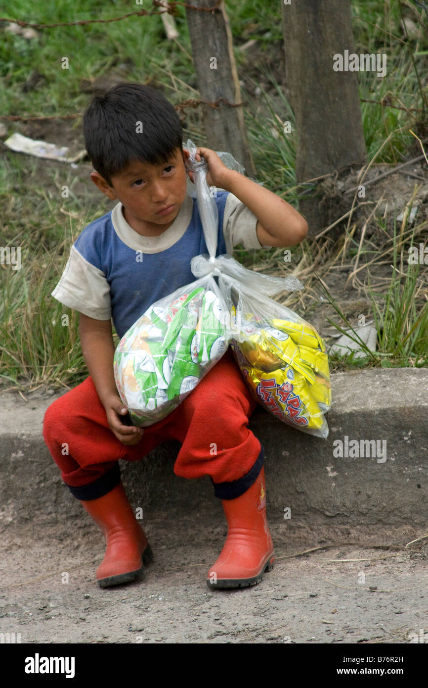 Poor Little boy with red boots with shopping bag of crisps. Ecuador ...