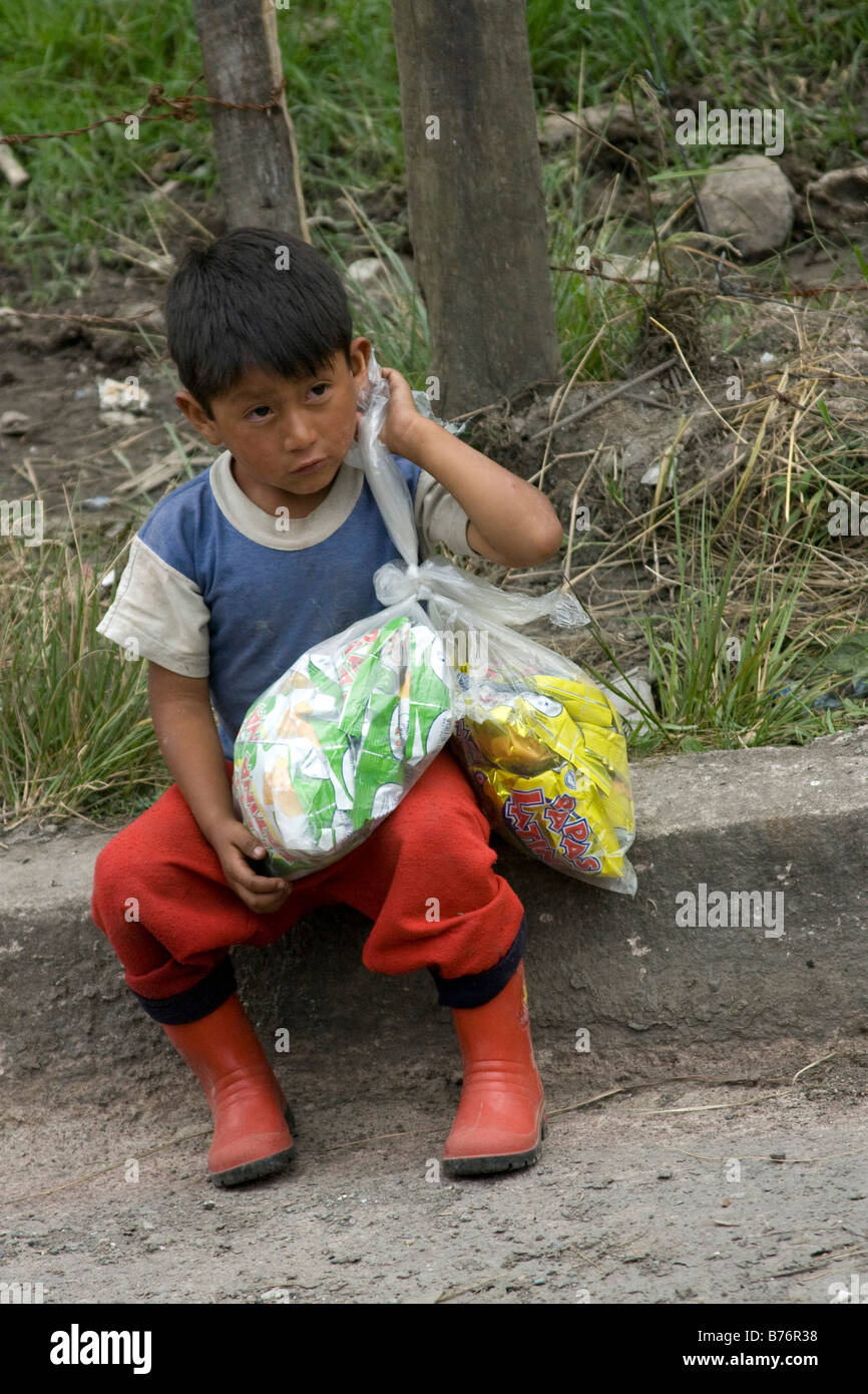 Poor Little boy with red boots with shopping bag of crisps. Ecuador ...