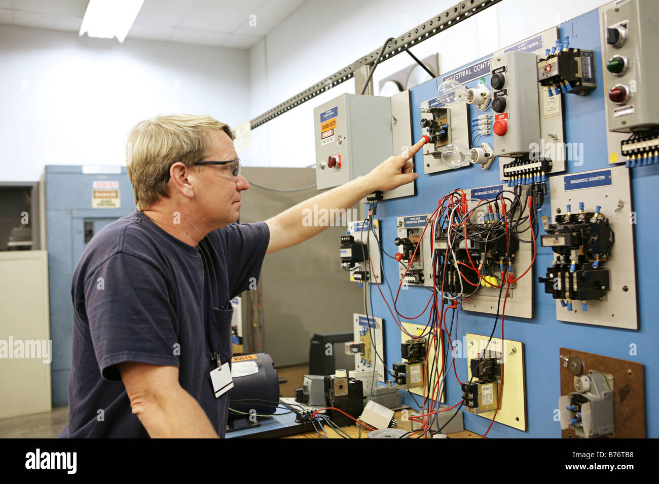 An electrical teacher working on an industrial motor control center in ...