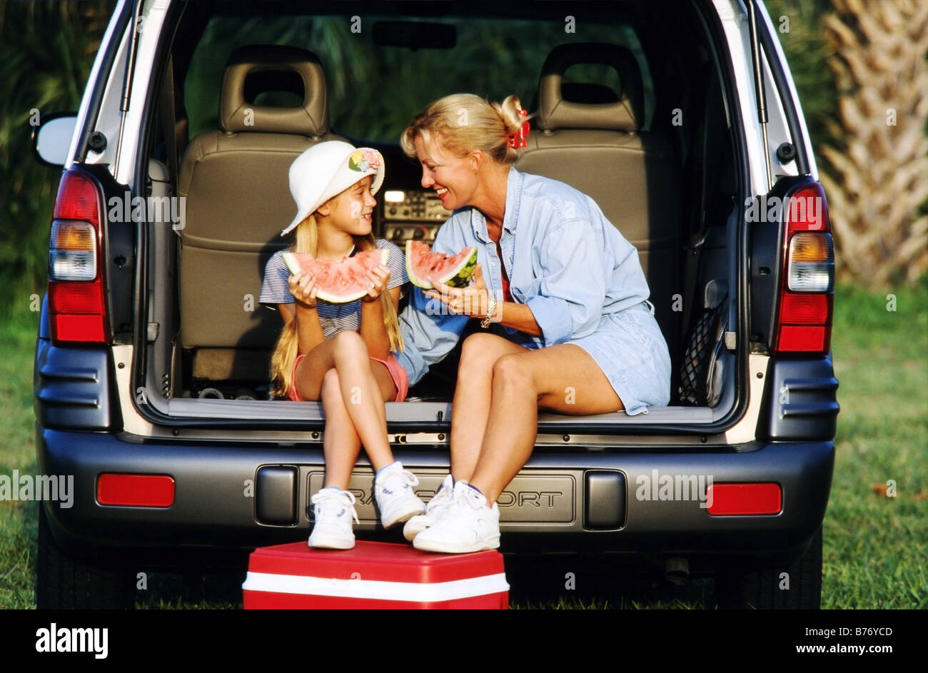 Mother and daughter together, having picnic on back on minivan Stock ...