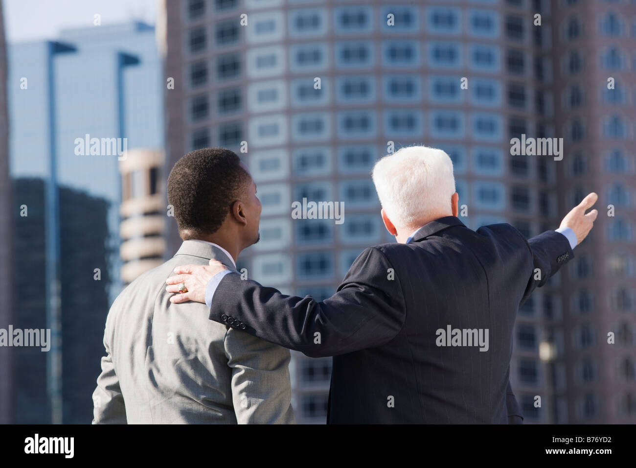 Two businessmen looking at office buildings, rear view Stock Photo - Alamy