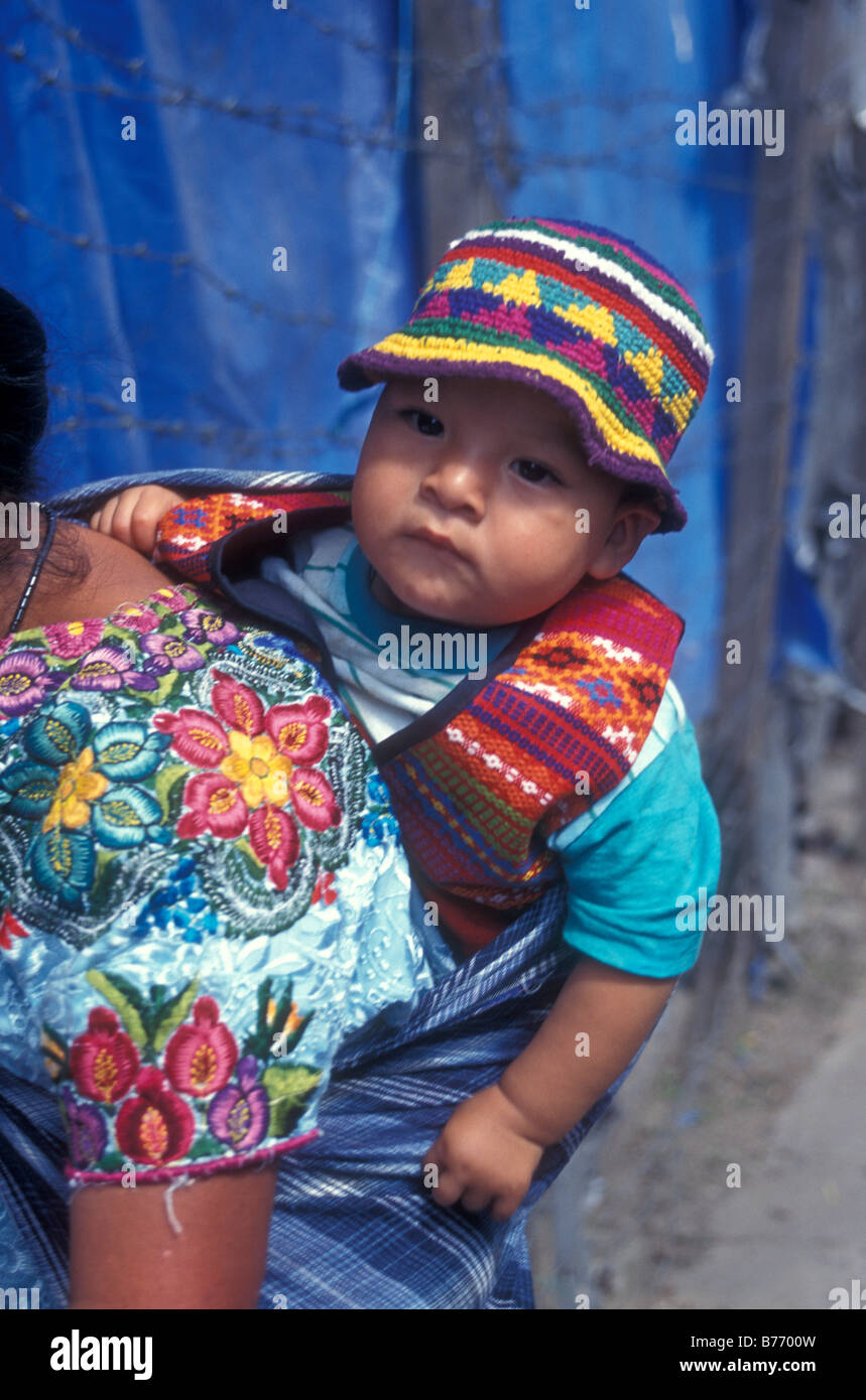 Chubby Mayan baby on his mother's back in the Spanish colonial town of ...