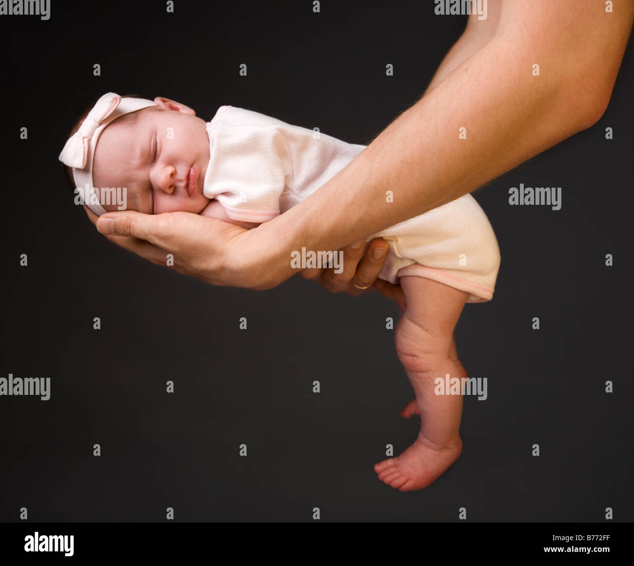 Supporting Hands. Father holding newborn sleeping baby on his hands ...