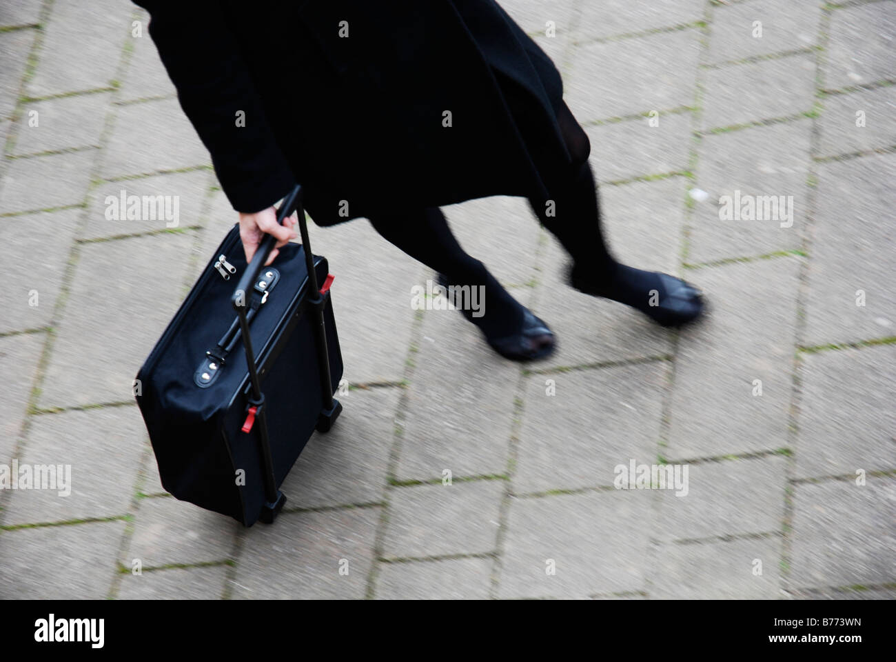Crop of young woman rushing with an overnight case Motion and panning ...