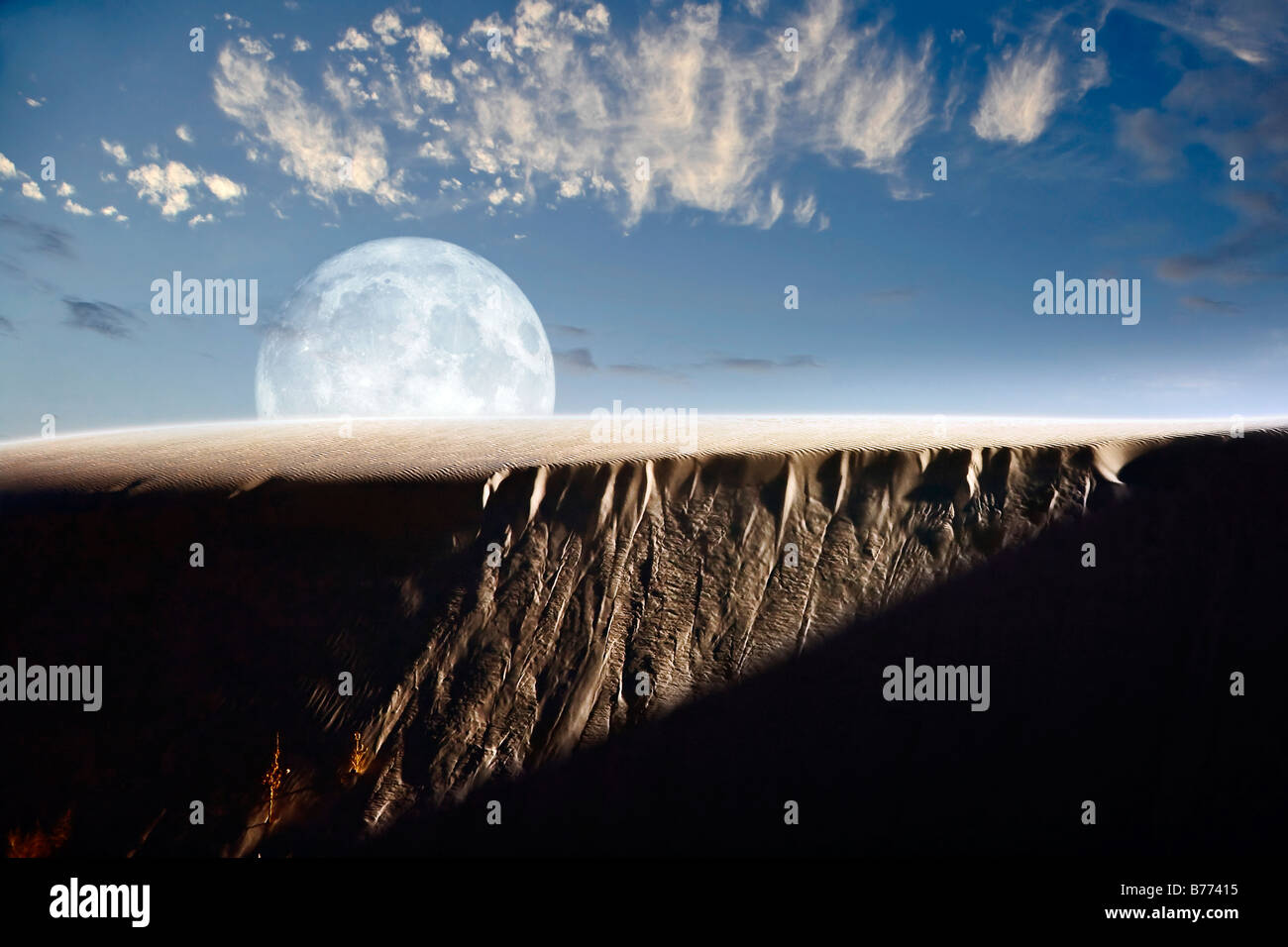 A larger than life depiction of the full moon rising above a sand dune ...