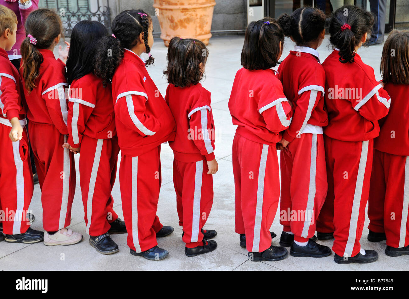 School children wearing red training uniforms, waiting in a row ...