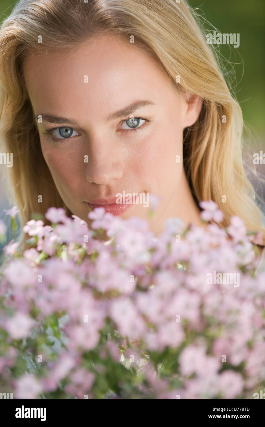 Woman posing behind flowers Stock Photo - Alamy