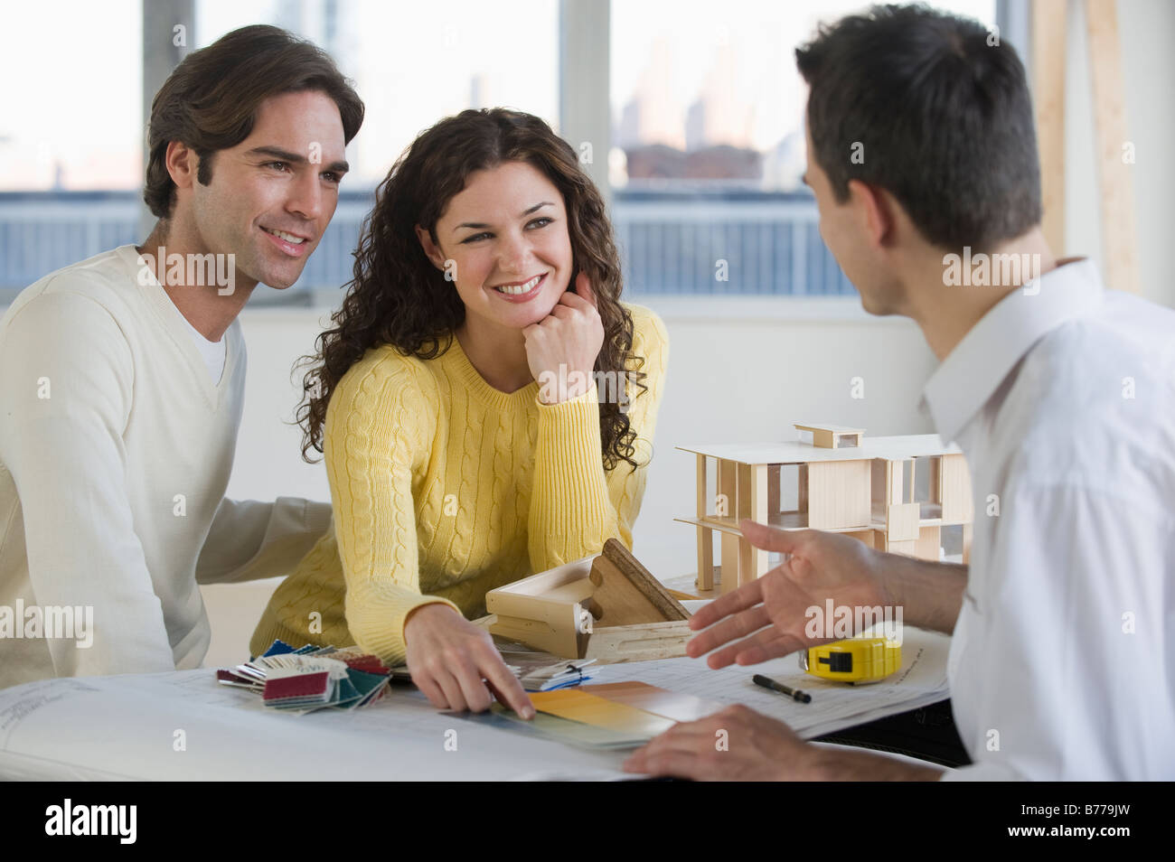 Architect presenting plans to couple Stock Photo - Alamy