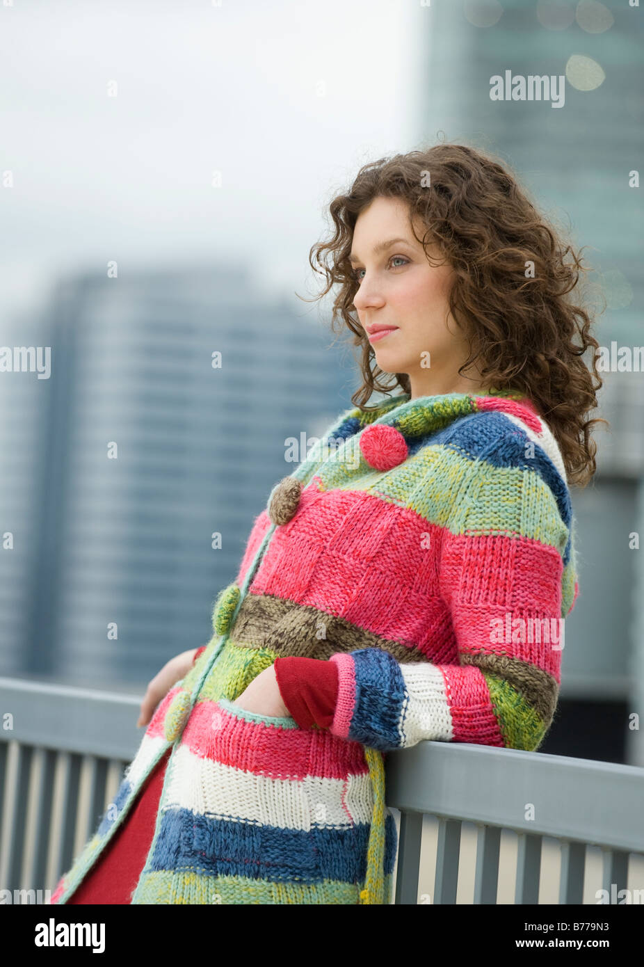 Woman leaning against railing Stock Photo - Alamy