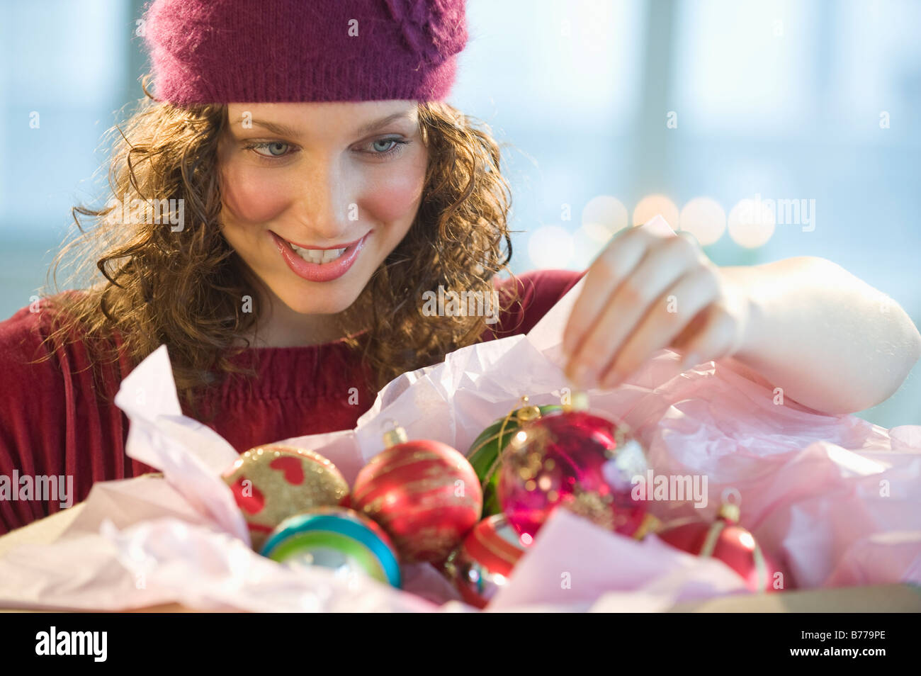 Woman unwrapping Christmas ornaments Stock Photo - Alamy