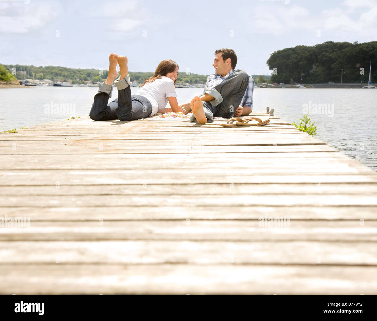 Couple laying on dock Stock Photo - Alamy