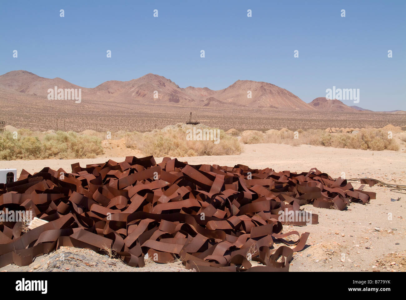 Rusty metal strips piled in the desert near an abandoned mining site ...