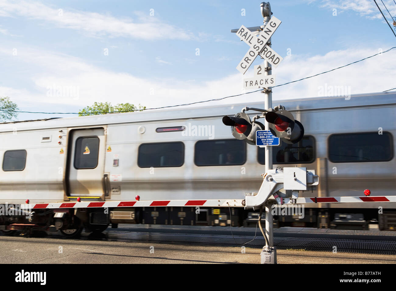 Commuter train moving through railroad crossing Stock Photo - Alamy