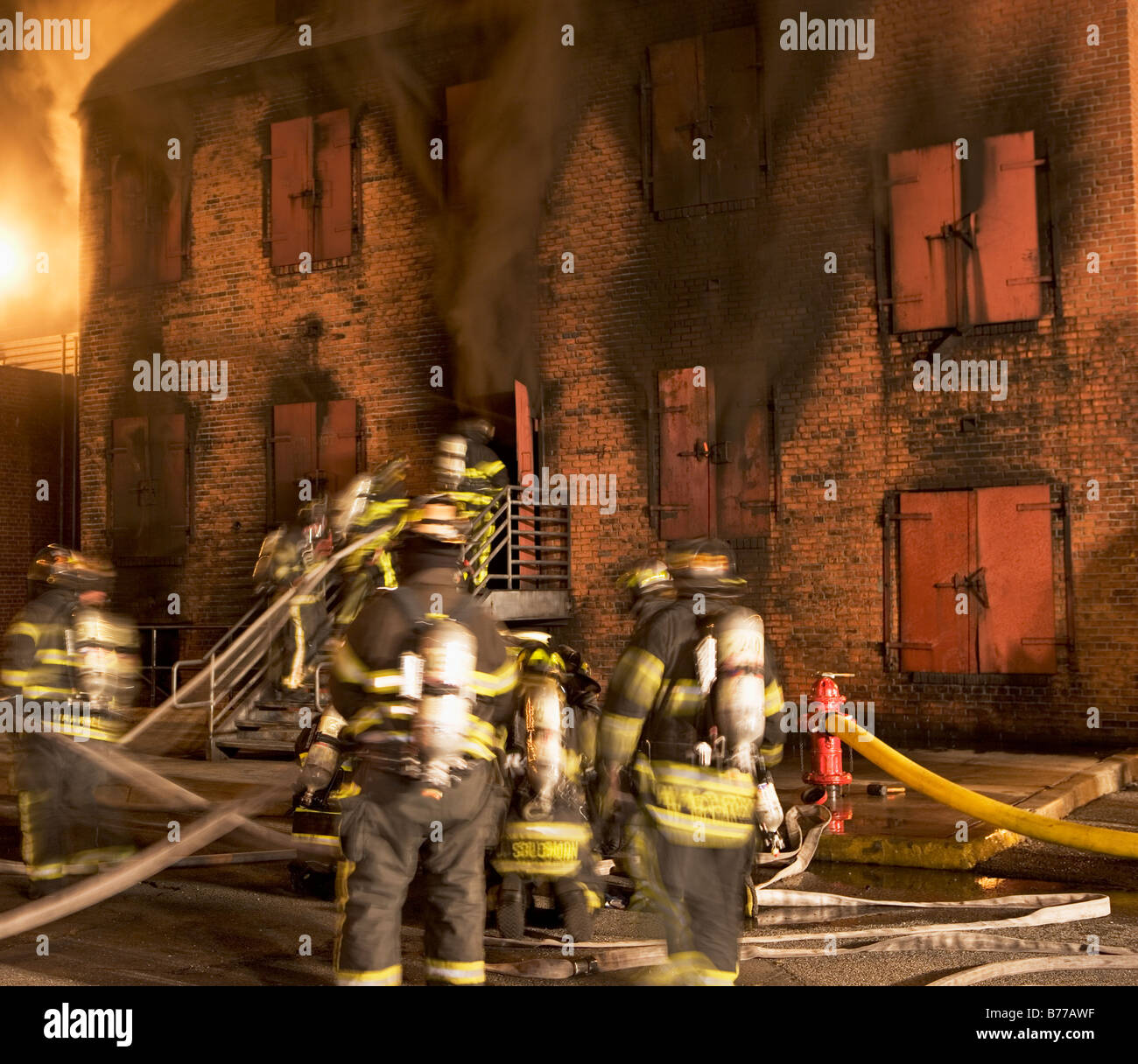 Firefighters burning building Stock Photo - Alamy