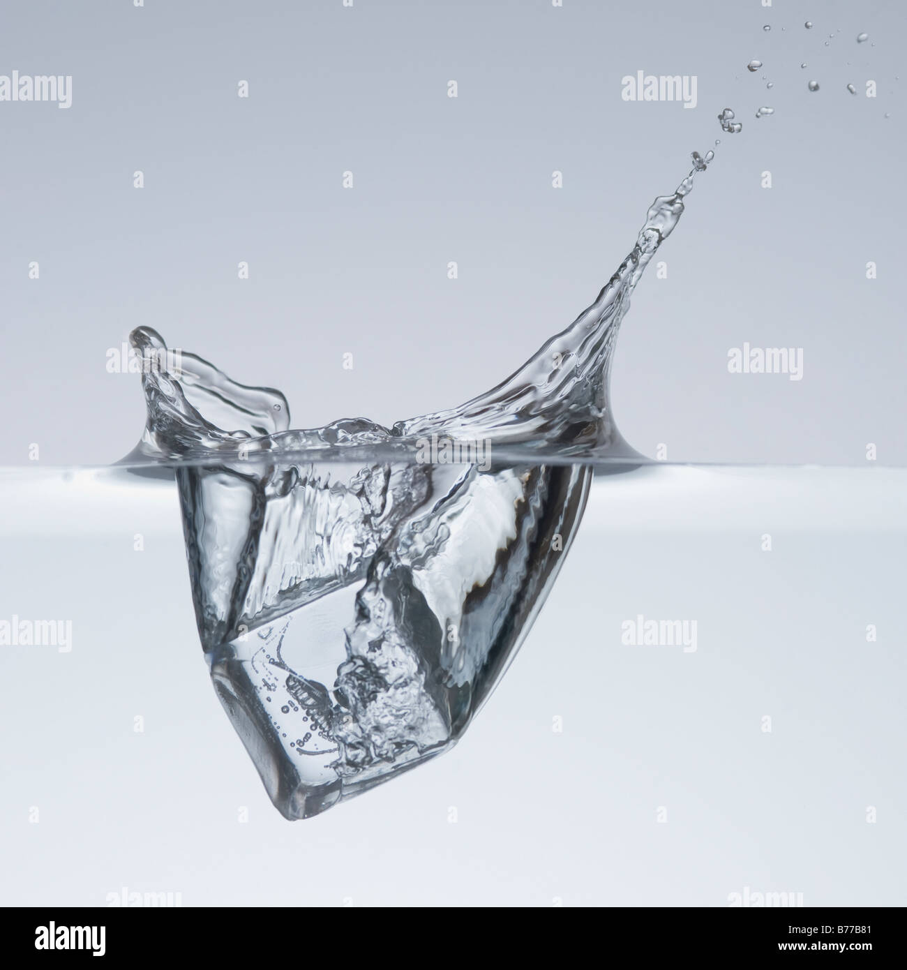 Ice cube splashing water Stock Photo - Alamy