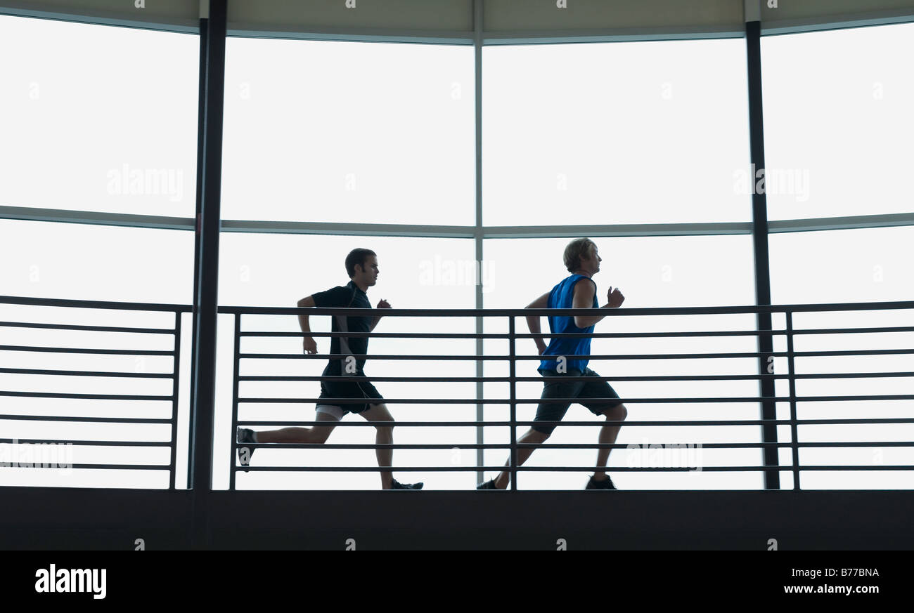 Men running on indoor track Stock Photo - Alamy