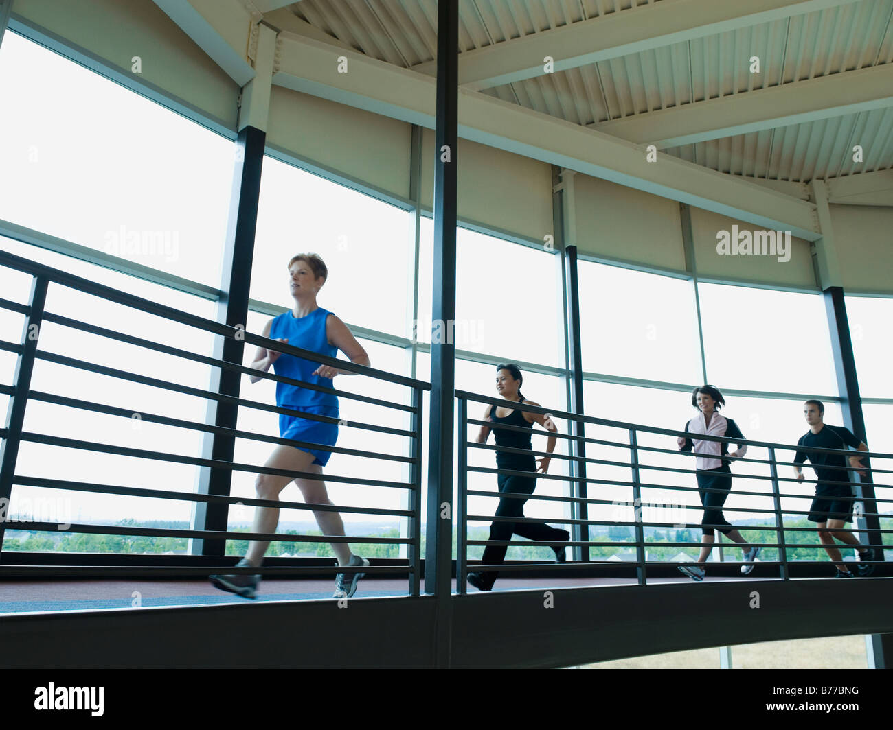 Men and women running on indoor track Stock Photo - Alamy