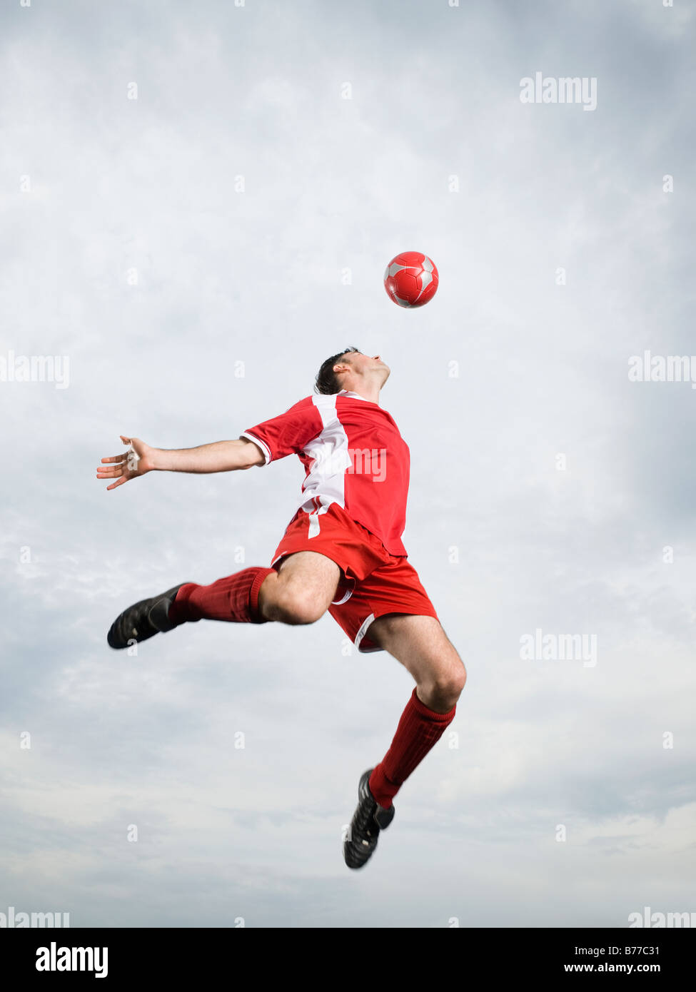 Soccer player and soccer ball mid-air Stock Photo - Alamy