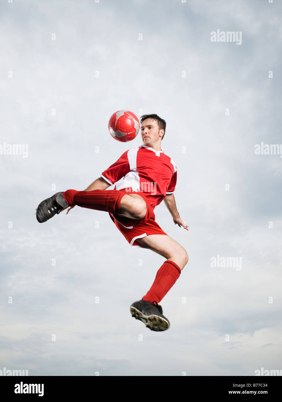 Soccer player kicking soccer ball mid-air Stock Photo - Alamy
