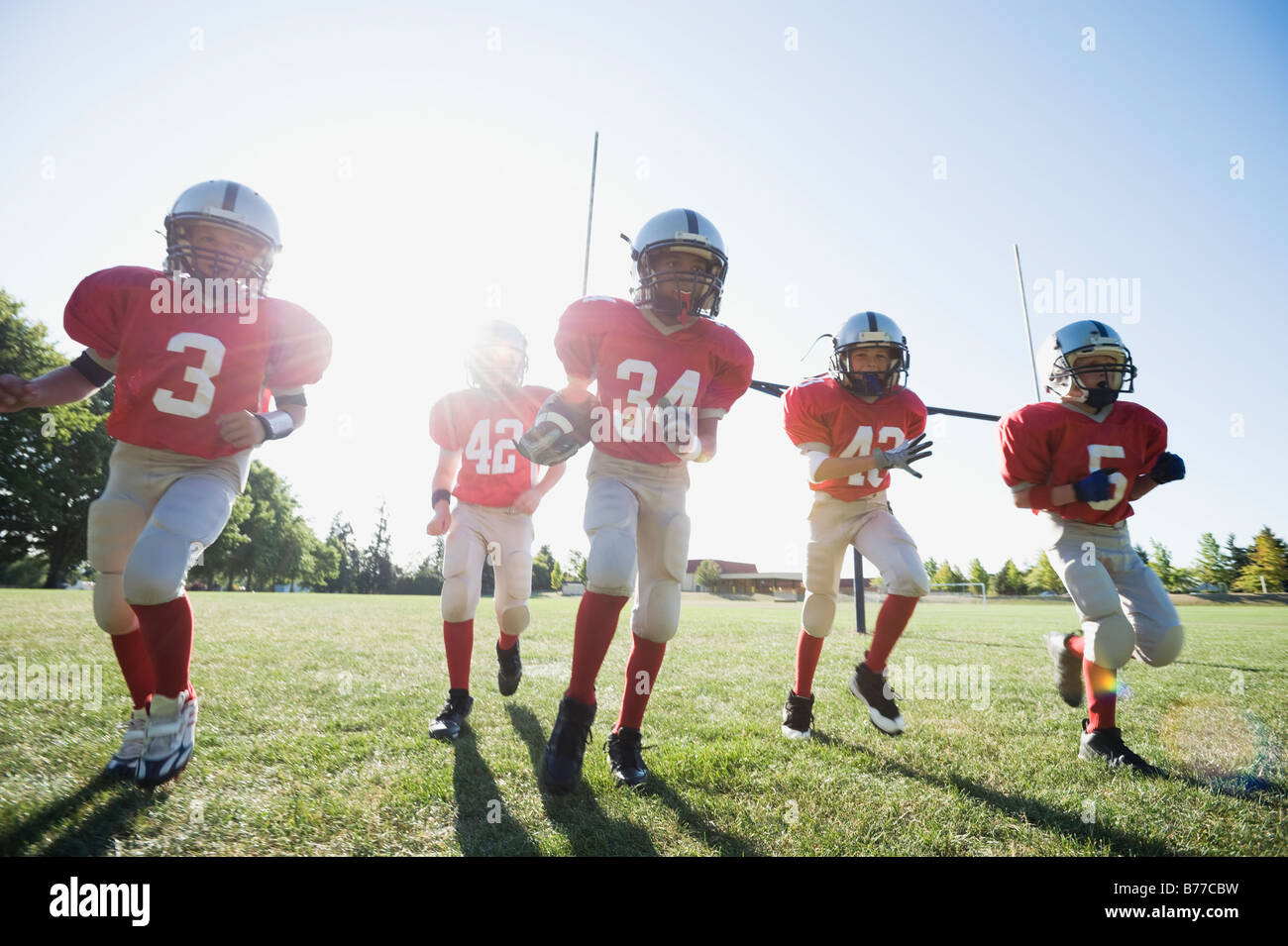 Football players running on field Stock Photo - Alamy
