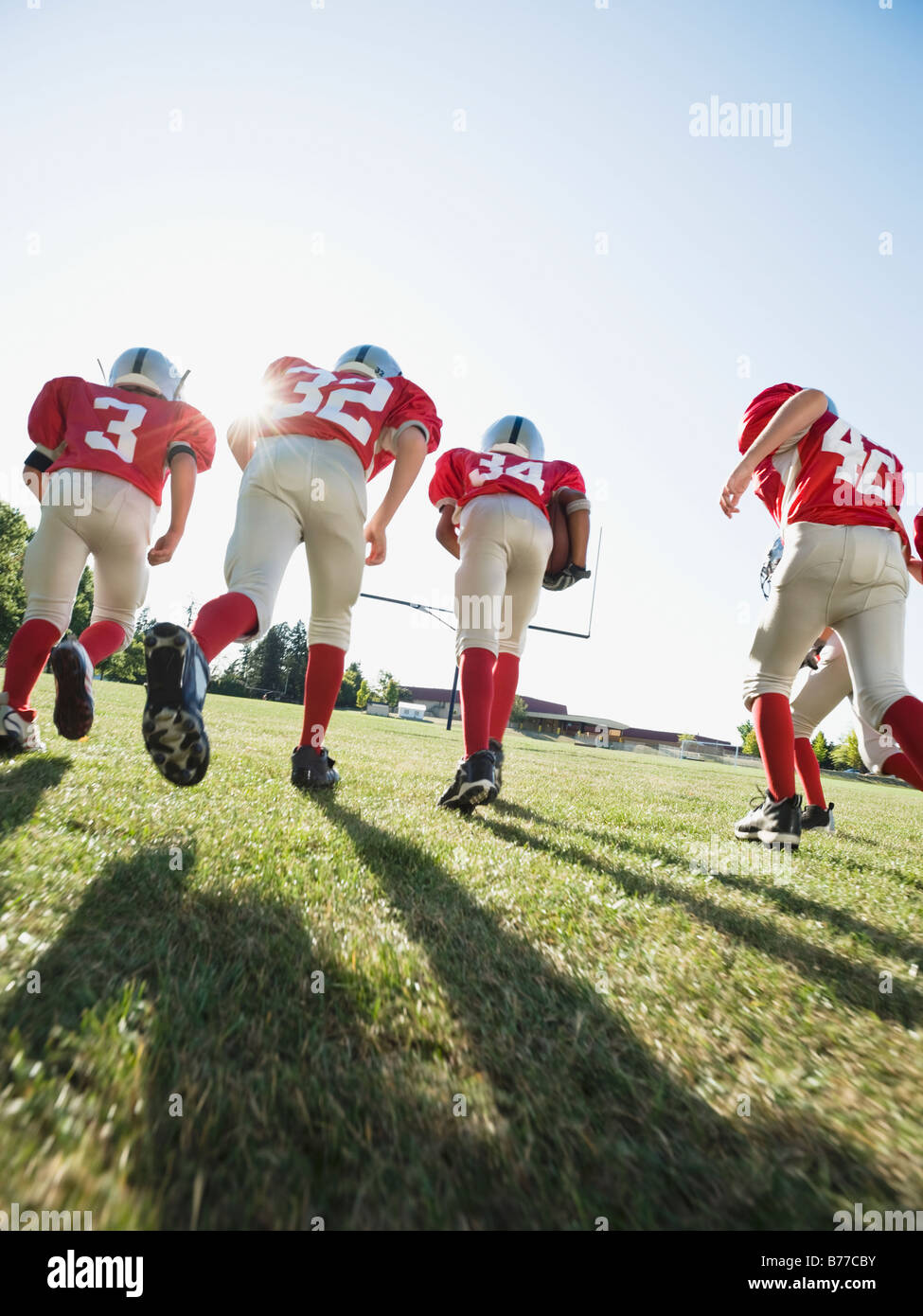 Football players running onto field Stock Photo - Alamy