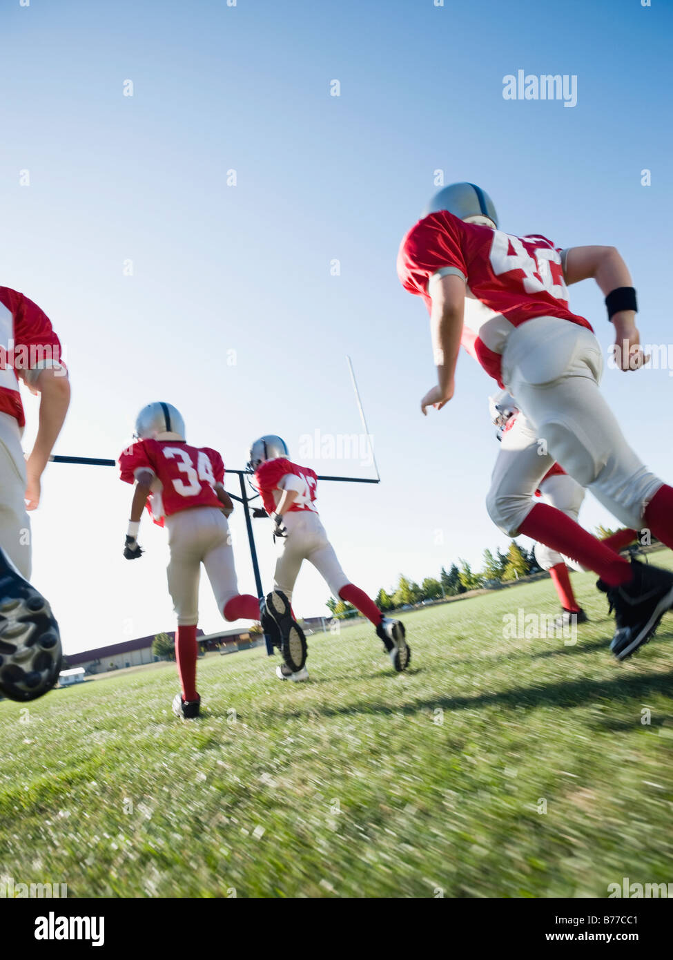 Football players running on field Stock Photo - Alamy